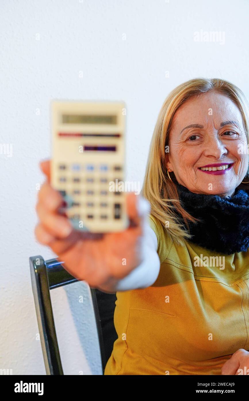 A mature woman showing the camera a calculator Stock Photo - Alamy