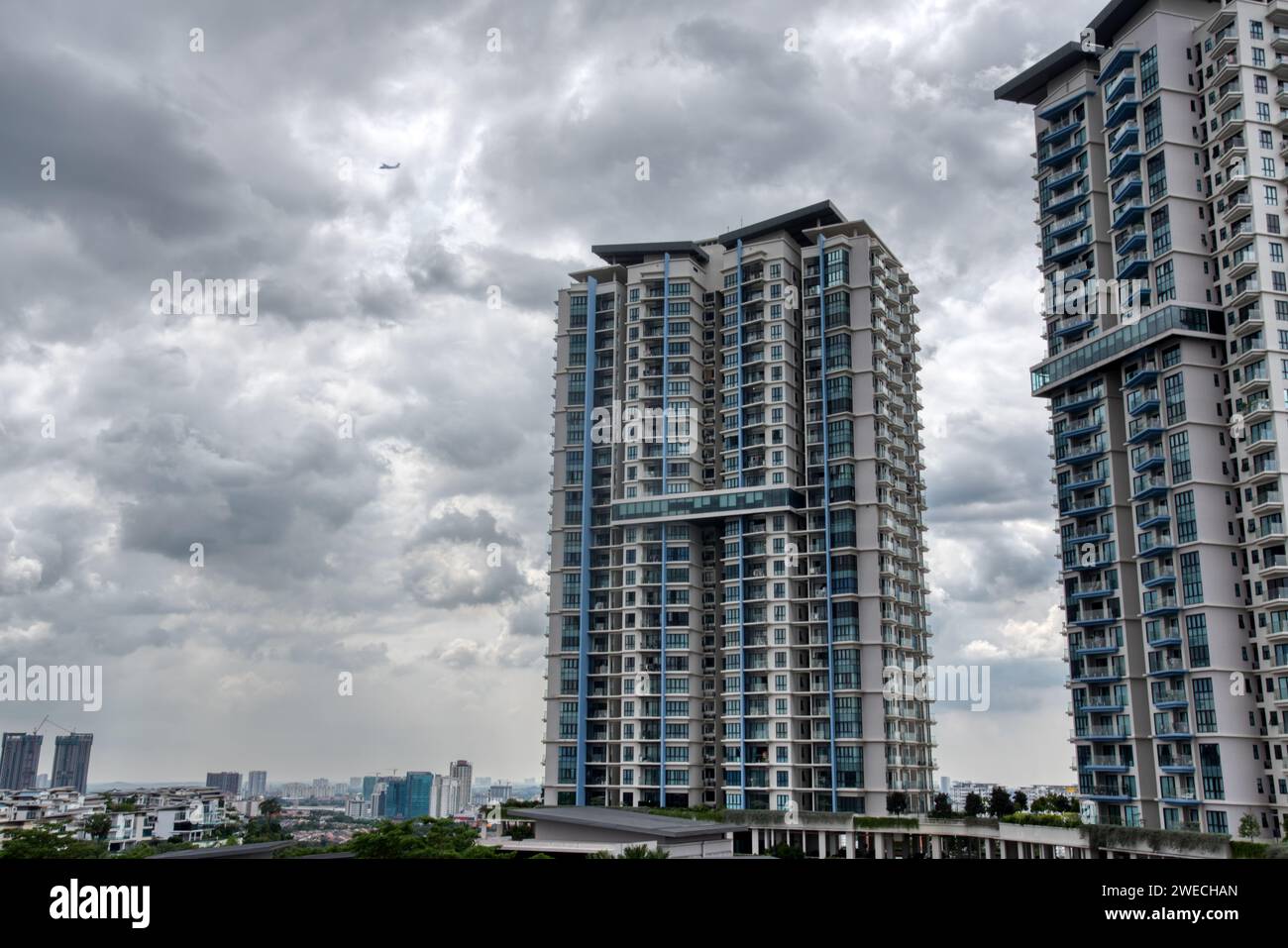 looking up the high rise urban building with an airplane flying over ...