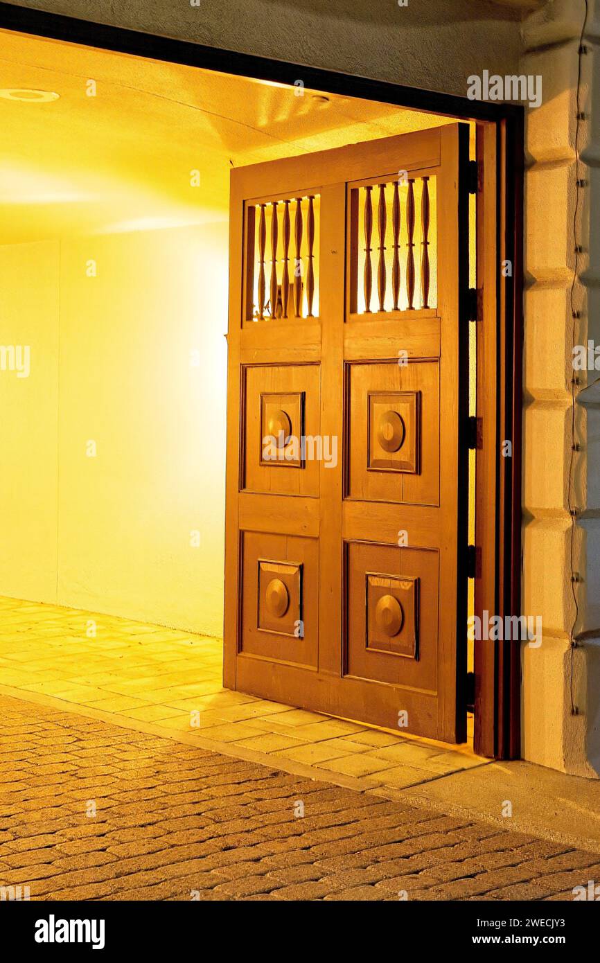 Brightly lit entryway with ornate wooden gate Stock Photo - Alamy