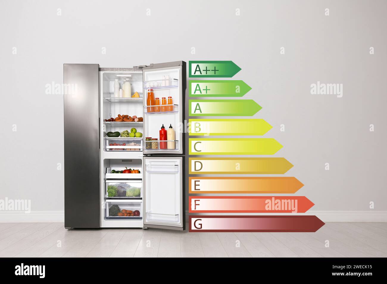 Energy efficiency rating label and open refrigerator near light wall ...