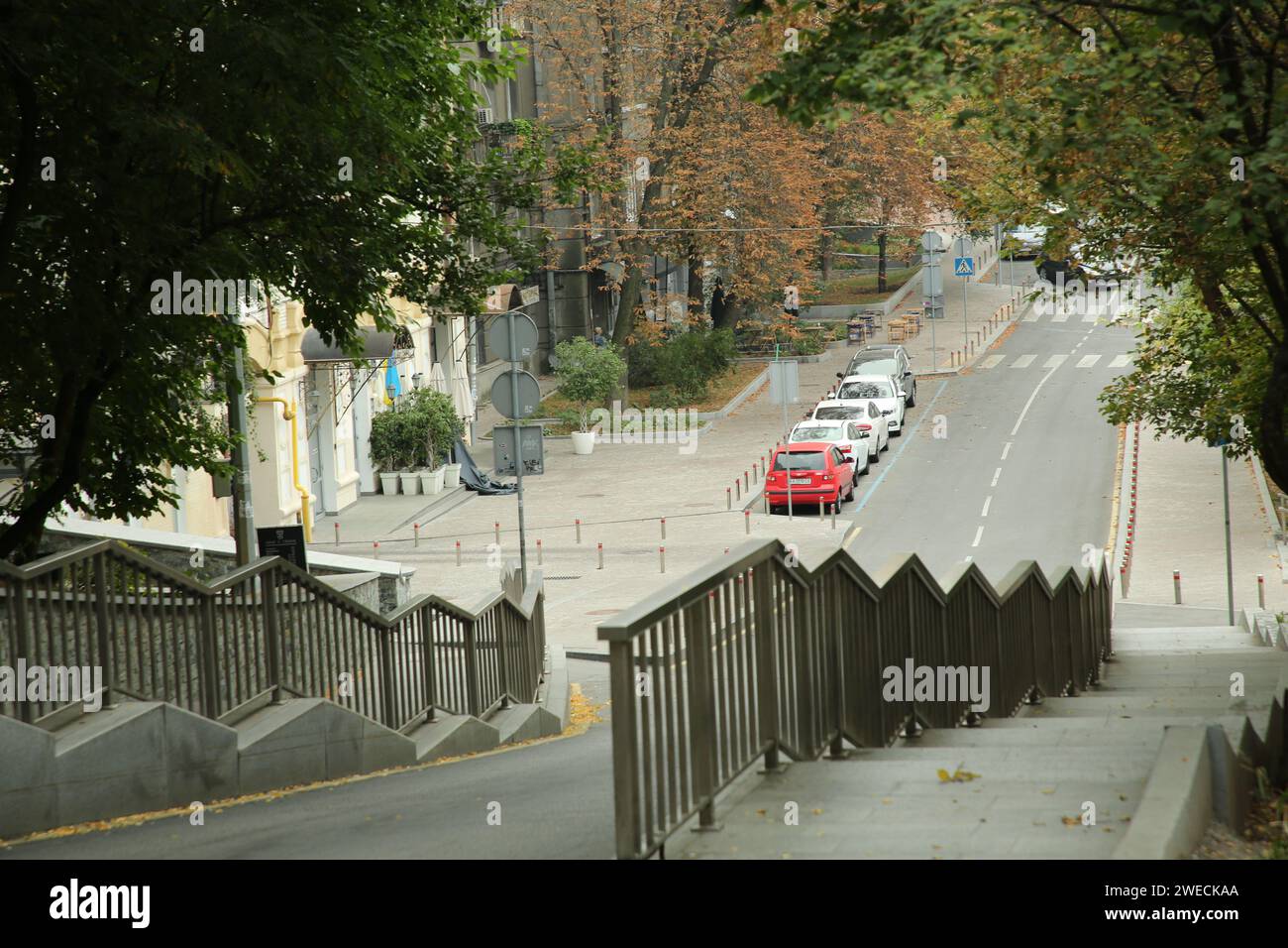 Picturesque view of quiet street with beautiful stairs, road and trees ...