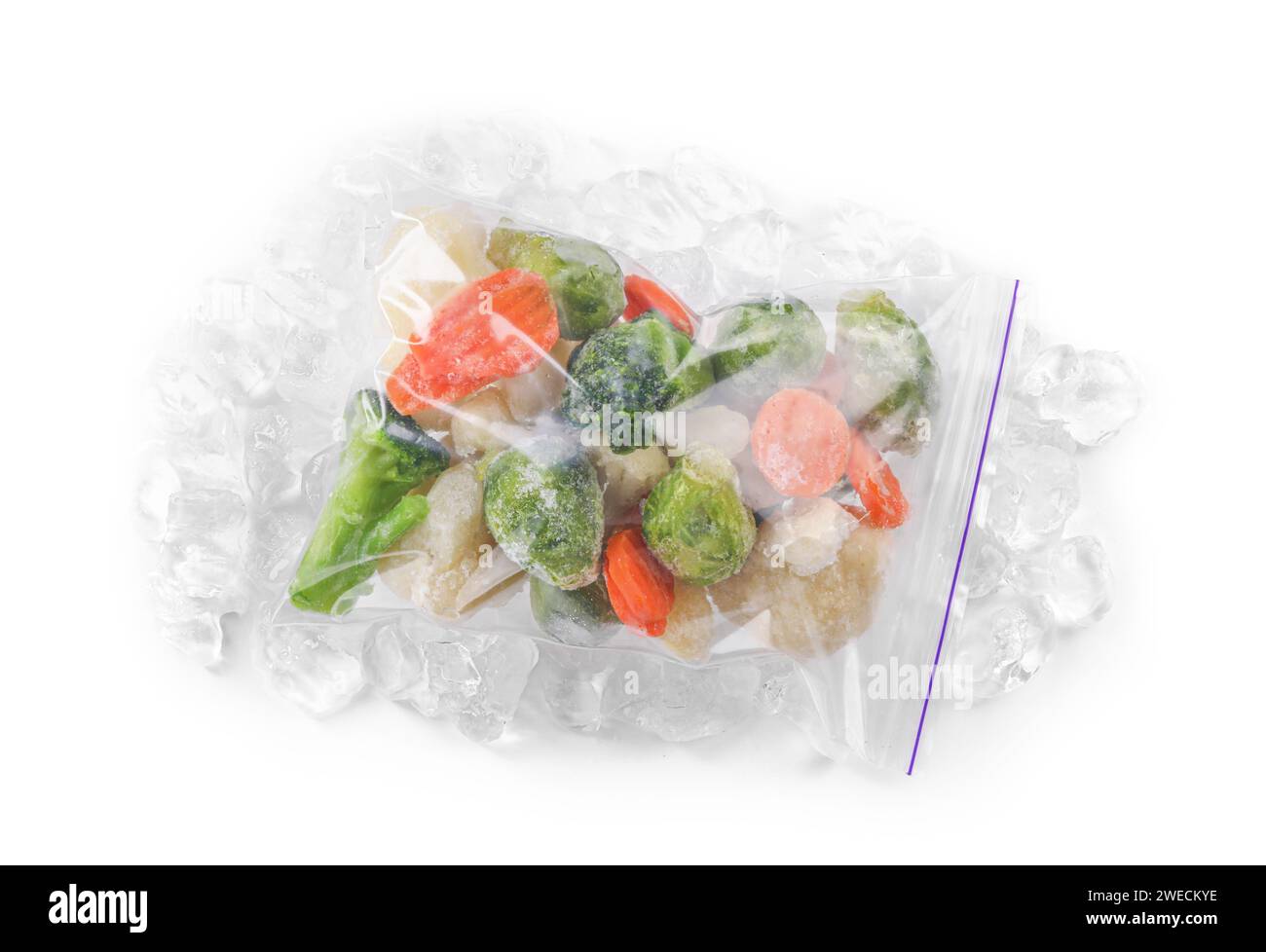 Mix of different frozen vegetables with ice isolated on white, top view ...