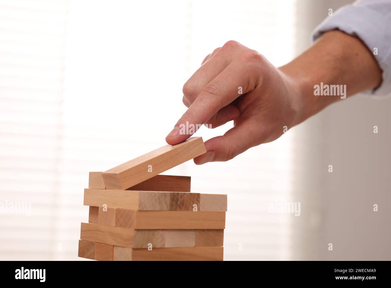 Playing Jenga. Man Building tower with wooden blocks, closeup Stock ...