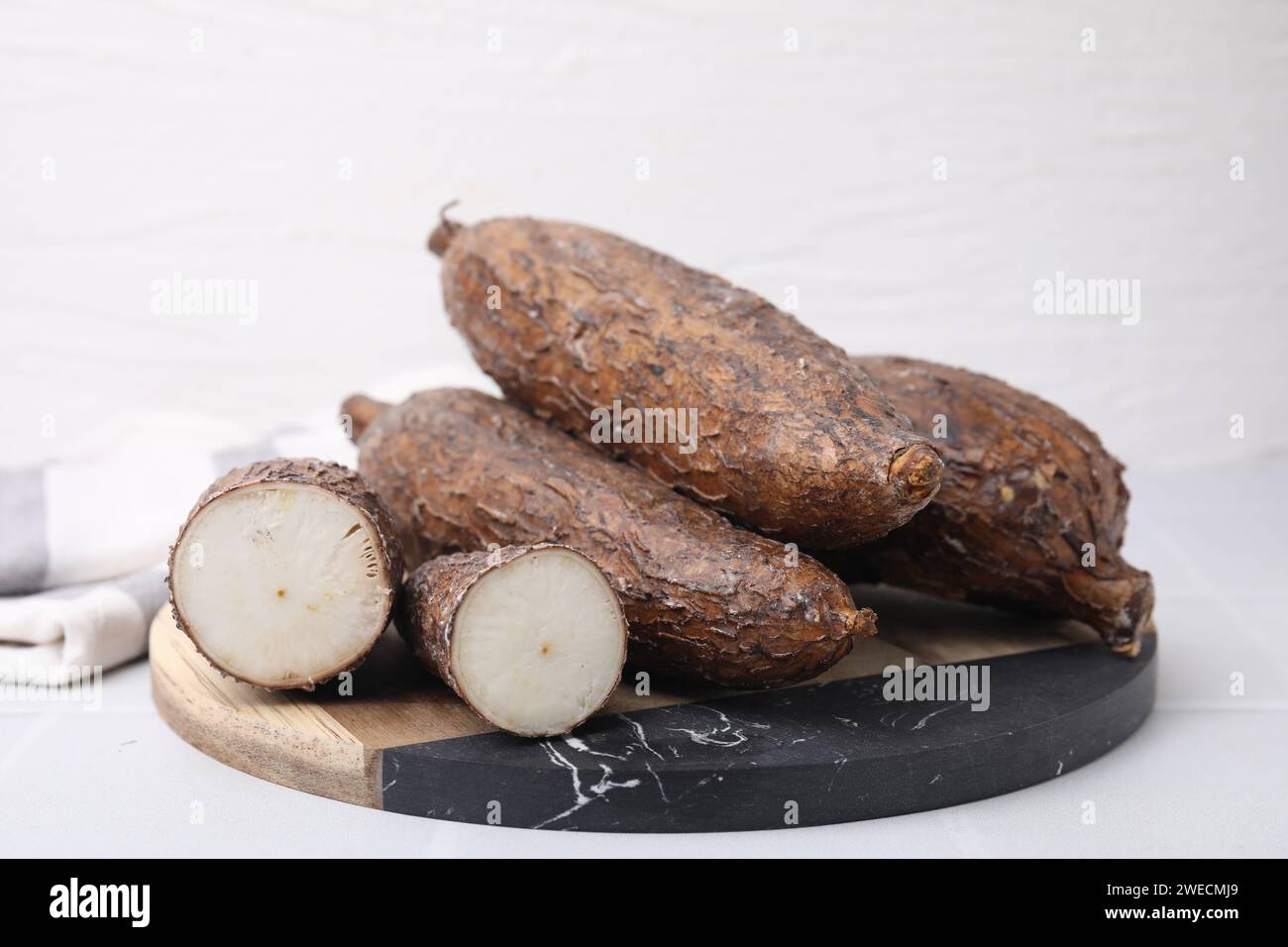 Whole and cut cassava roots on white table Stock Photo - Alamy