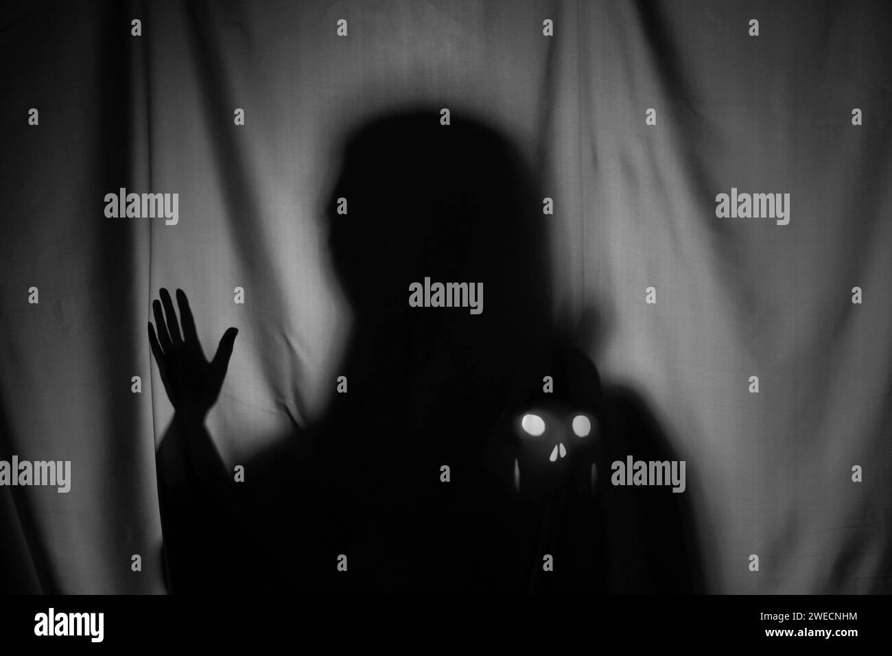 Silhouette of creepy ghost with skull behind grey cloth Stock Photo - Alamy
