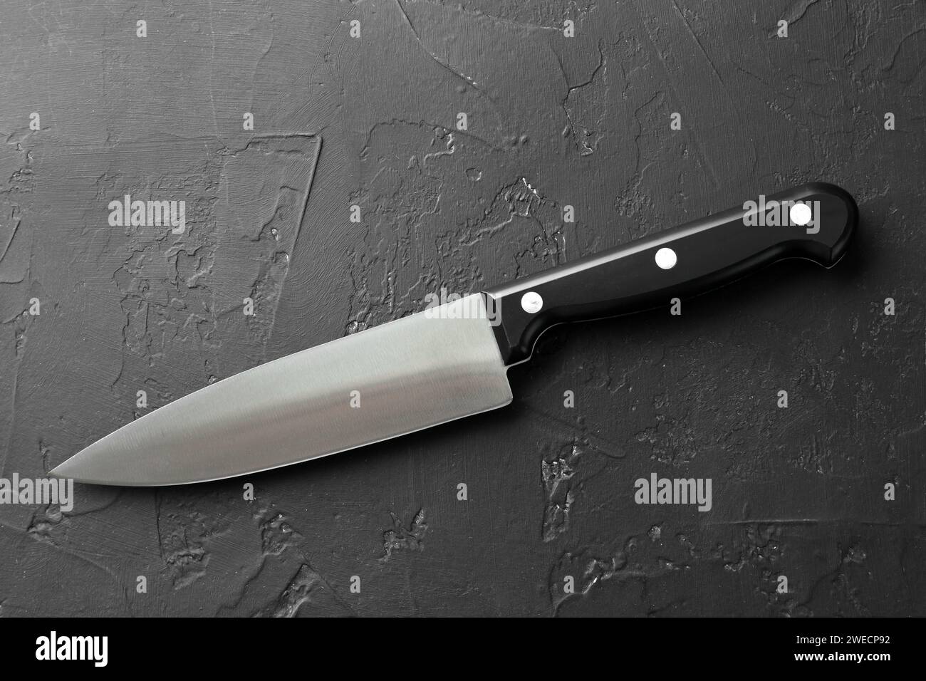One sharp knife on dark textured table, top view Stock Photo - Alamy