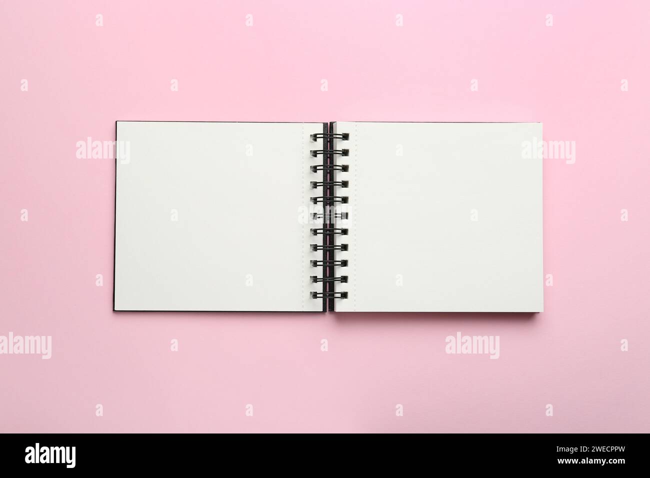 Open notebook on pink background, top view Stock Photo - Alamy