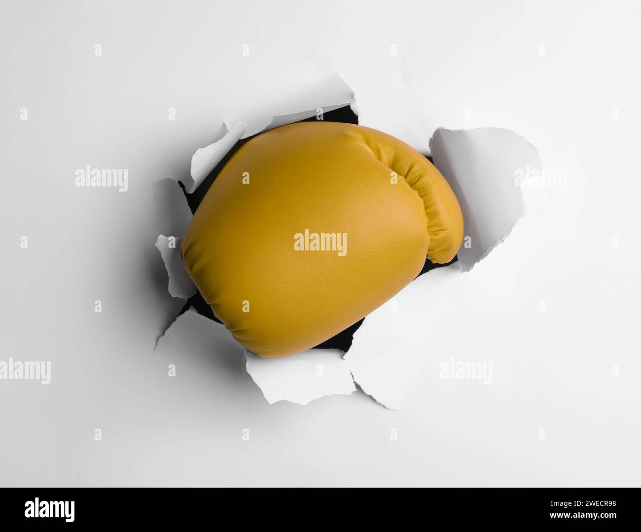 Breaking through white paper with boxing glove Stock Photo - Alamy