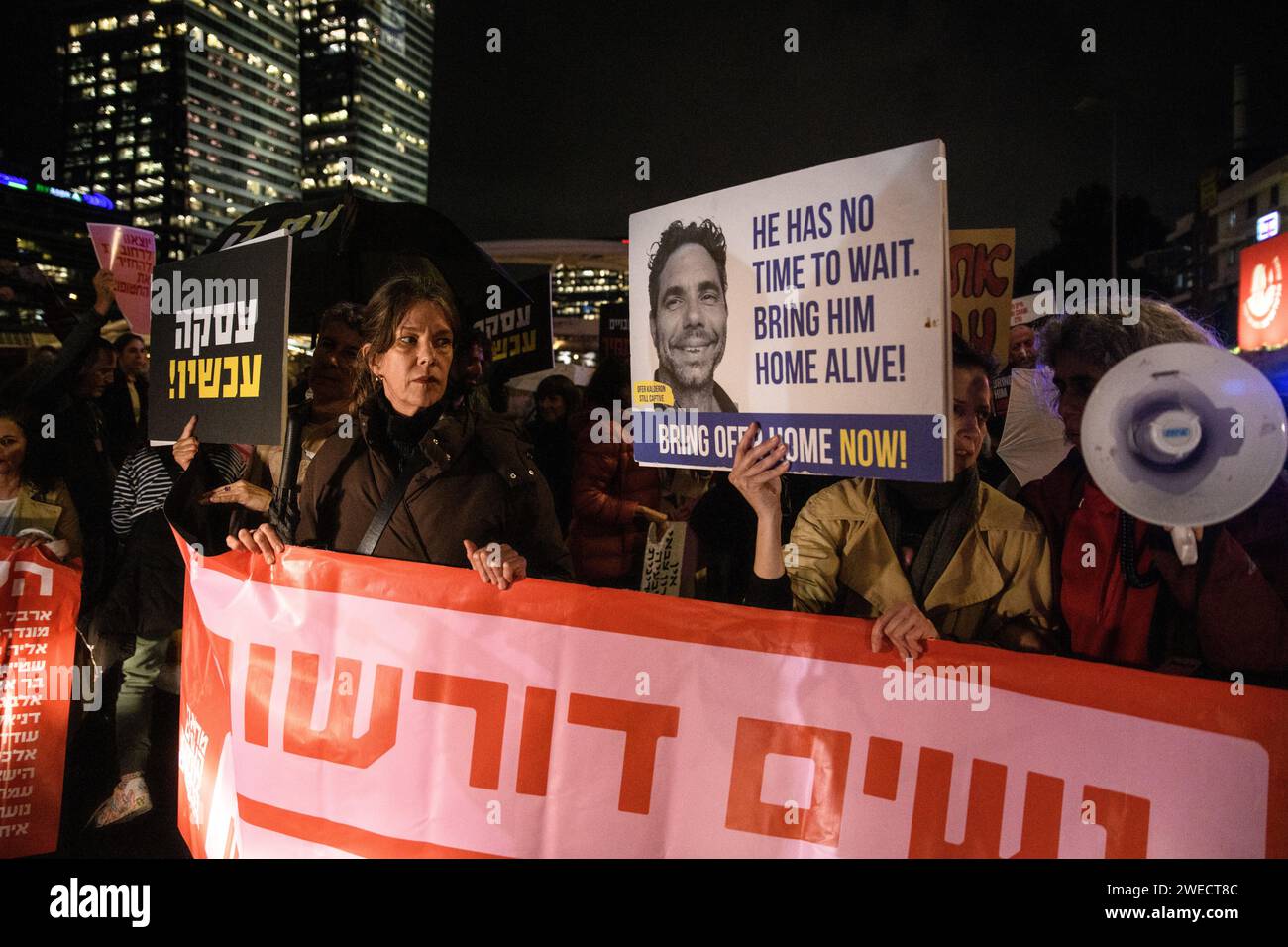 Israel. 24th Jan, 2024. An Israeli woman looks at a sign with the photo ...