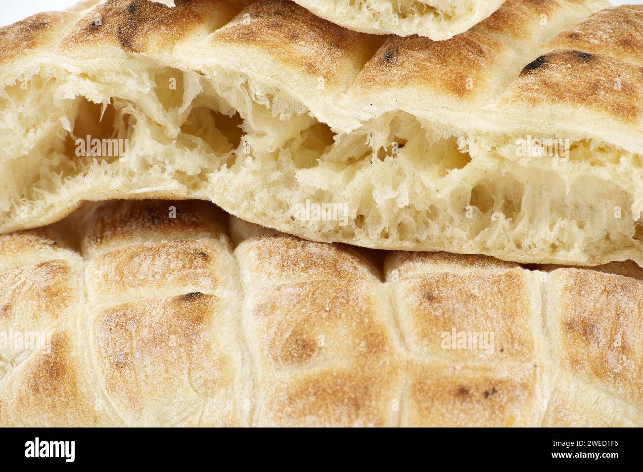 Pieces of pita flat-bread are stacked atop each other isolated on white ...