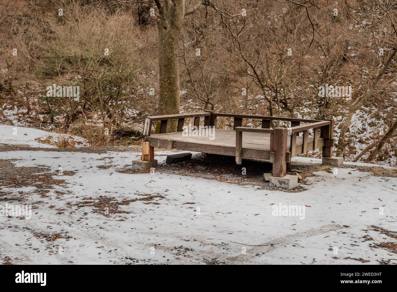 Old dilapidated wooden Korean picnic table in wilderness park on winter ...