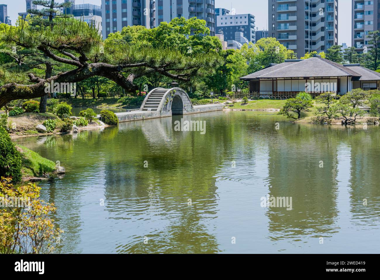 Concrete bridge across lake at Shukkeien Gardens in Hiroshima, Japan ...