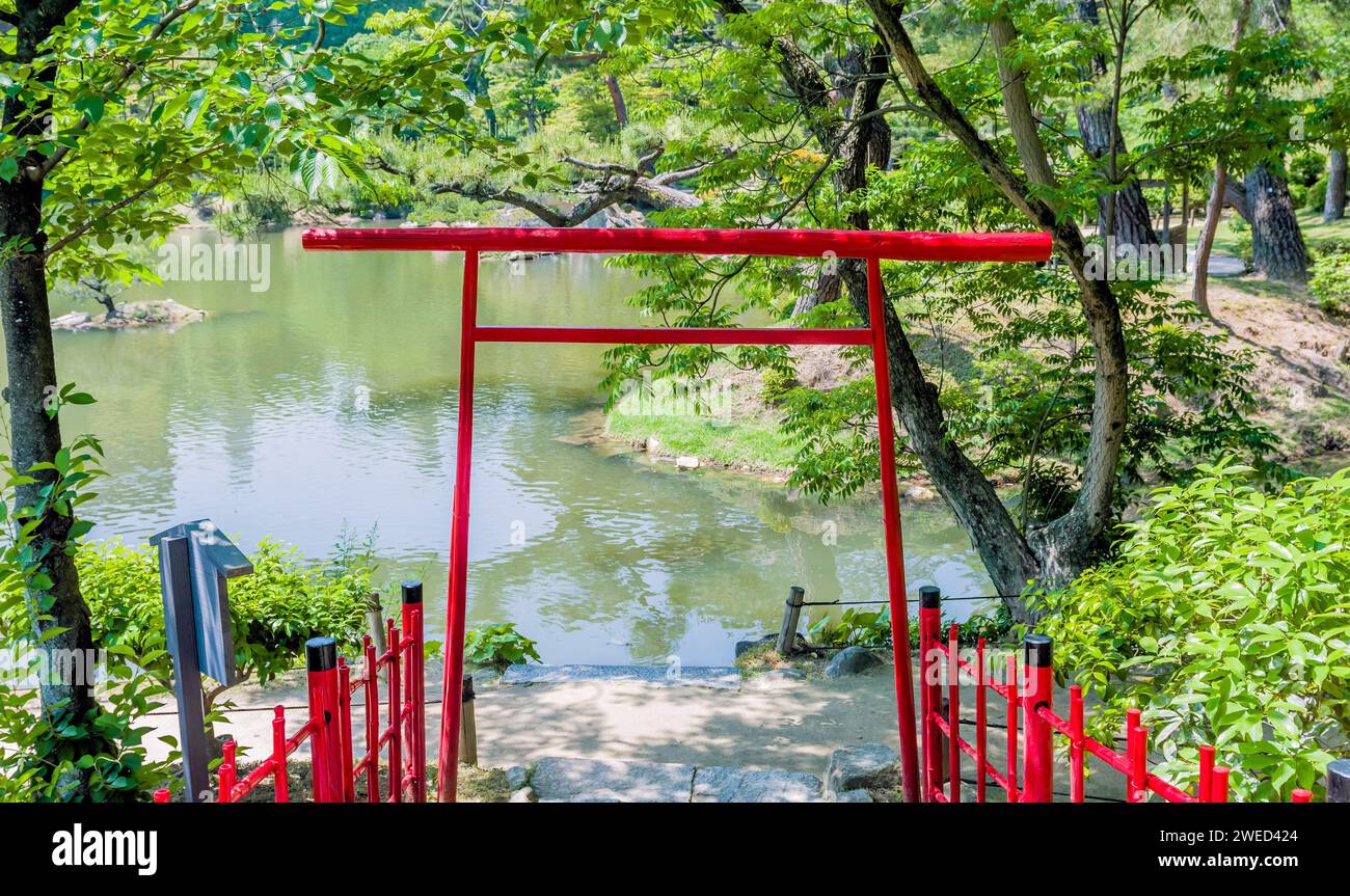 Torii Shinto gate under shade trees in Japanese garden in Hiroshima ...