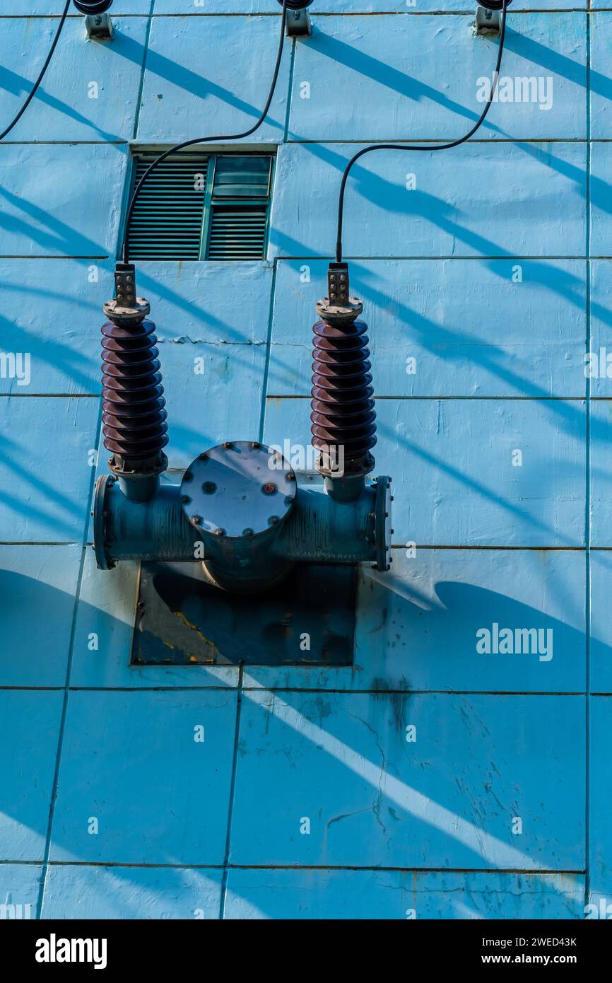High voltage power lines with ceramic insulators on side of power ...