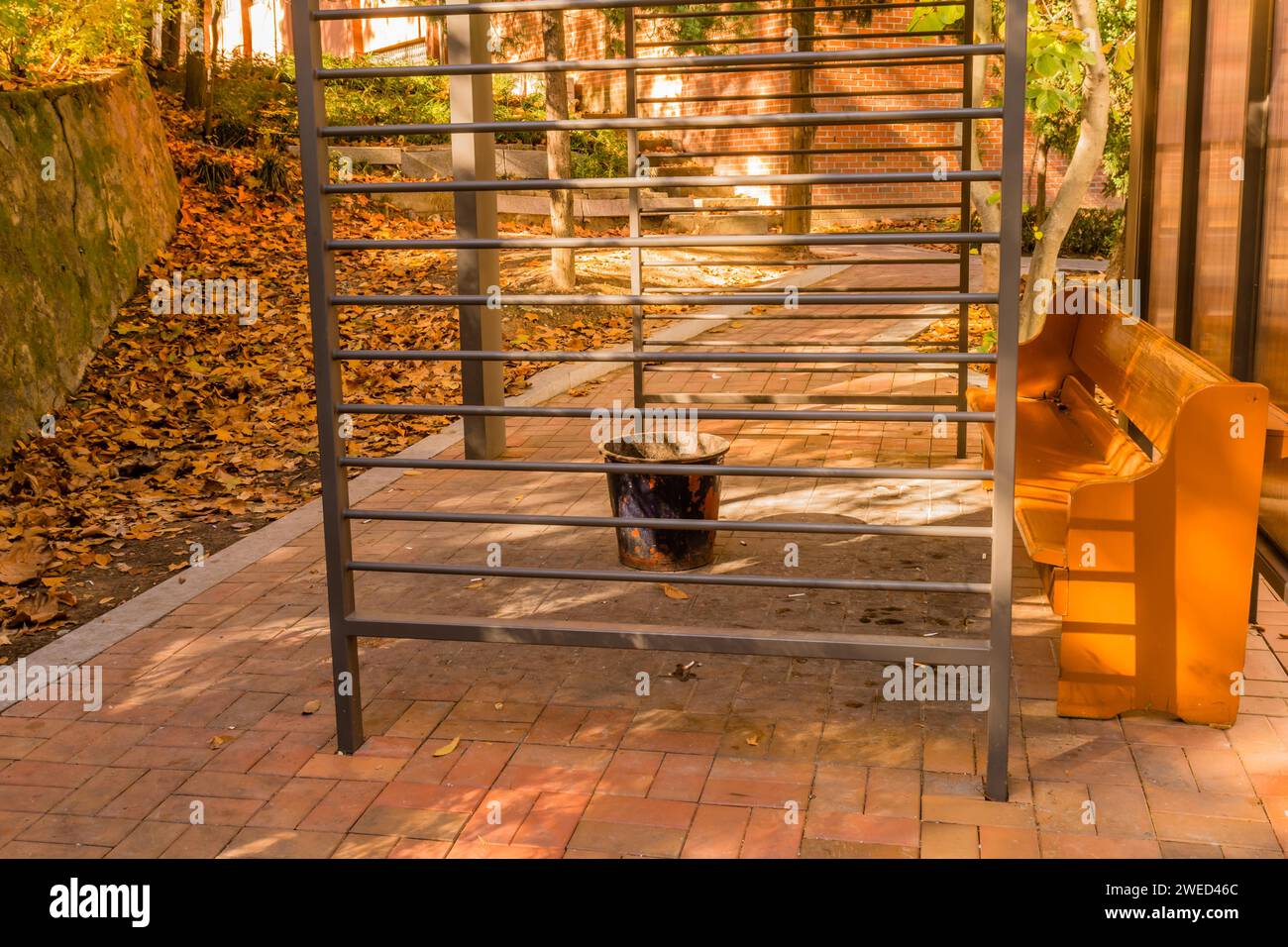 Dirty, littered public smoking area with wooden bench and ash can Stock ...