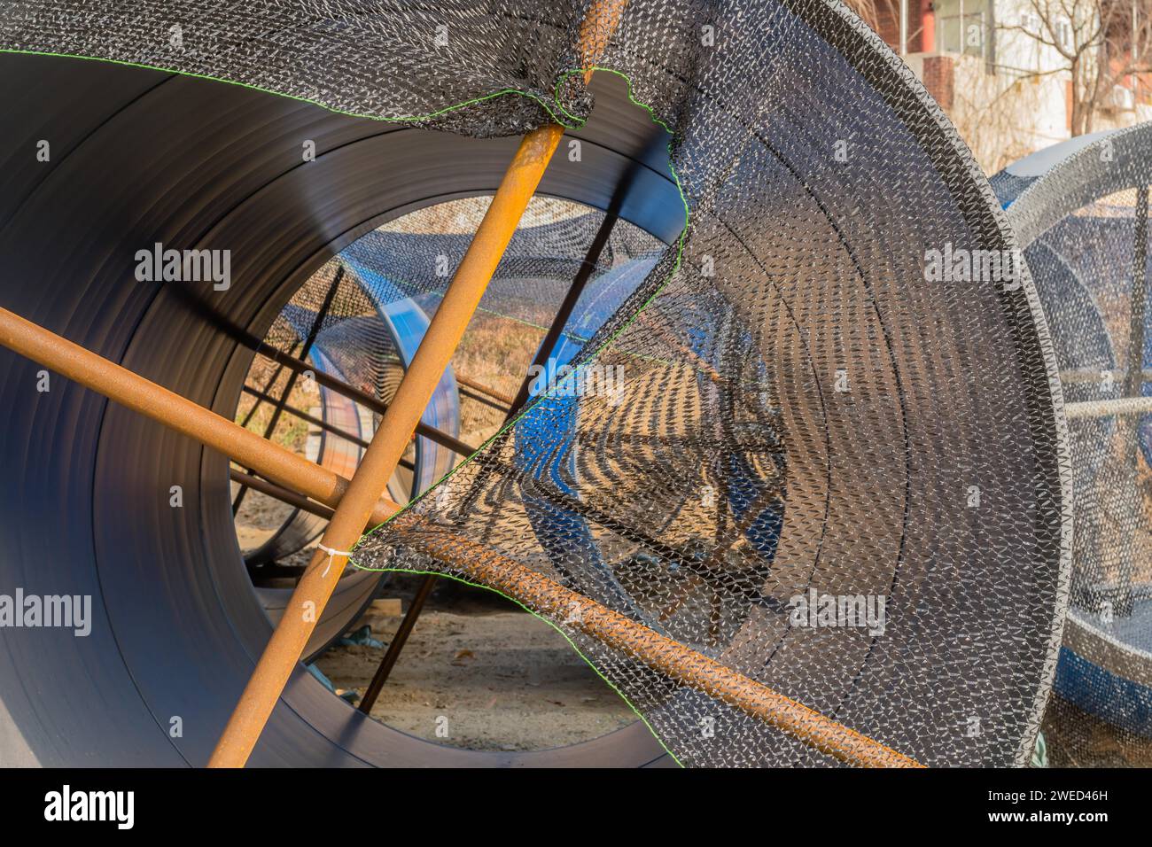 Closeup of large blue sections of steel industrial pipes sitting at ...