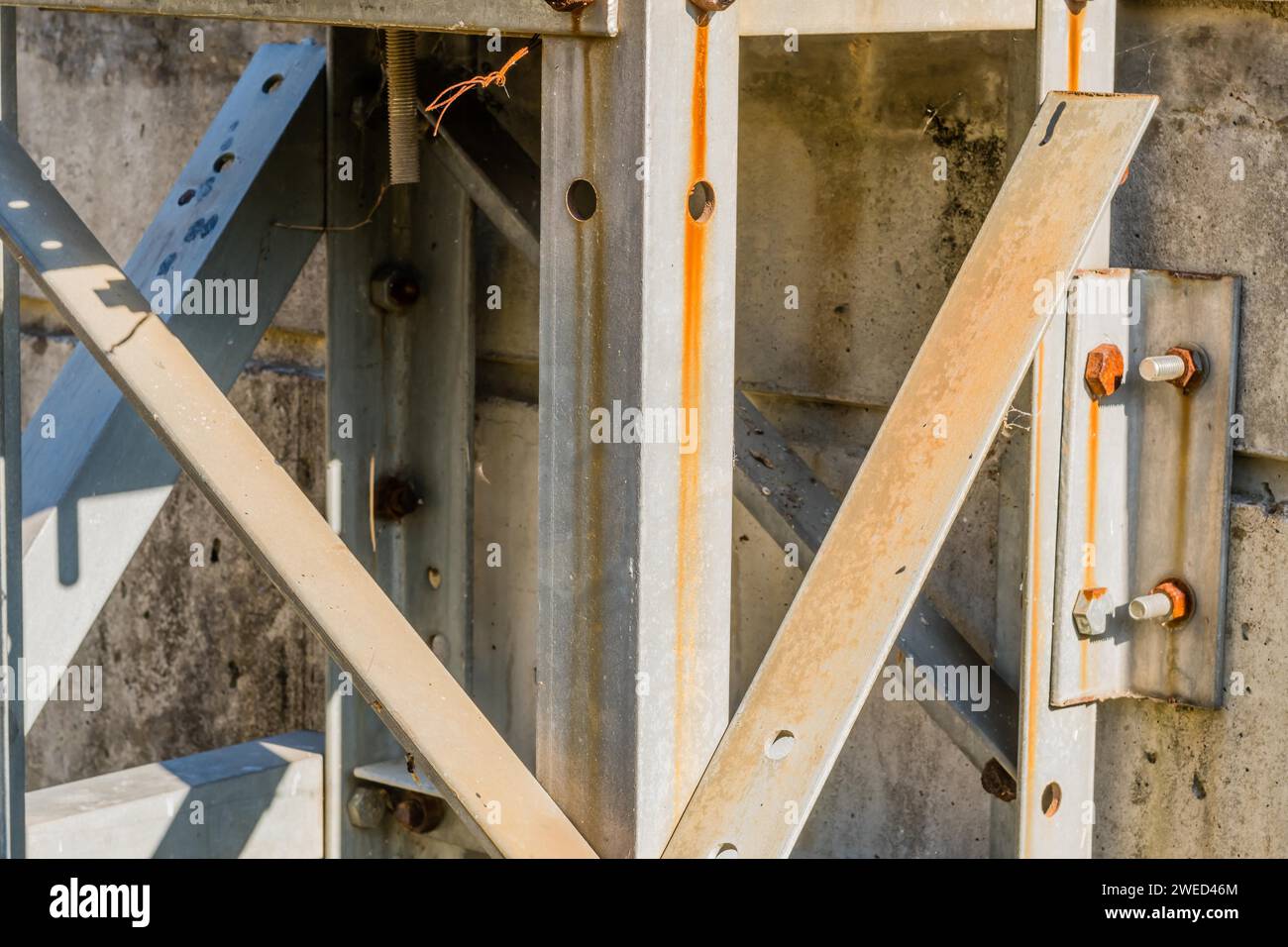 Closeup of metal support frame bolted to concrete wall on sunny day ...