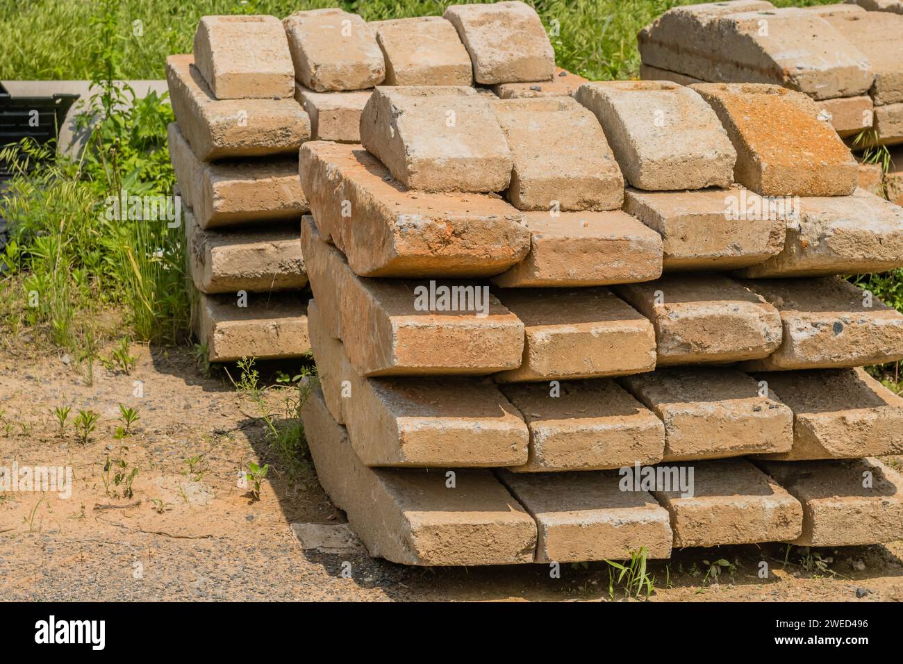 Curved concrete bricks used to support large utility poles stacked in ...