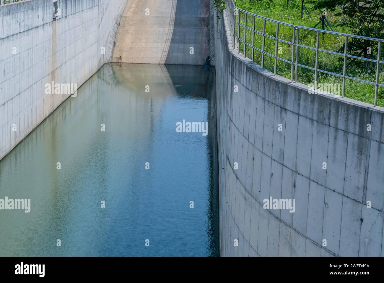 Pool of placid water at bottom of concrete spillway Stock Photo - Alamy