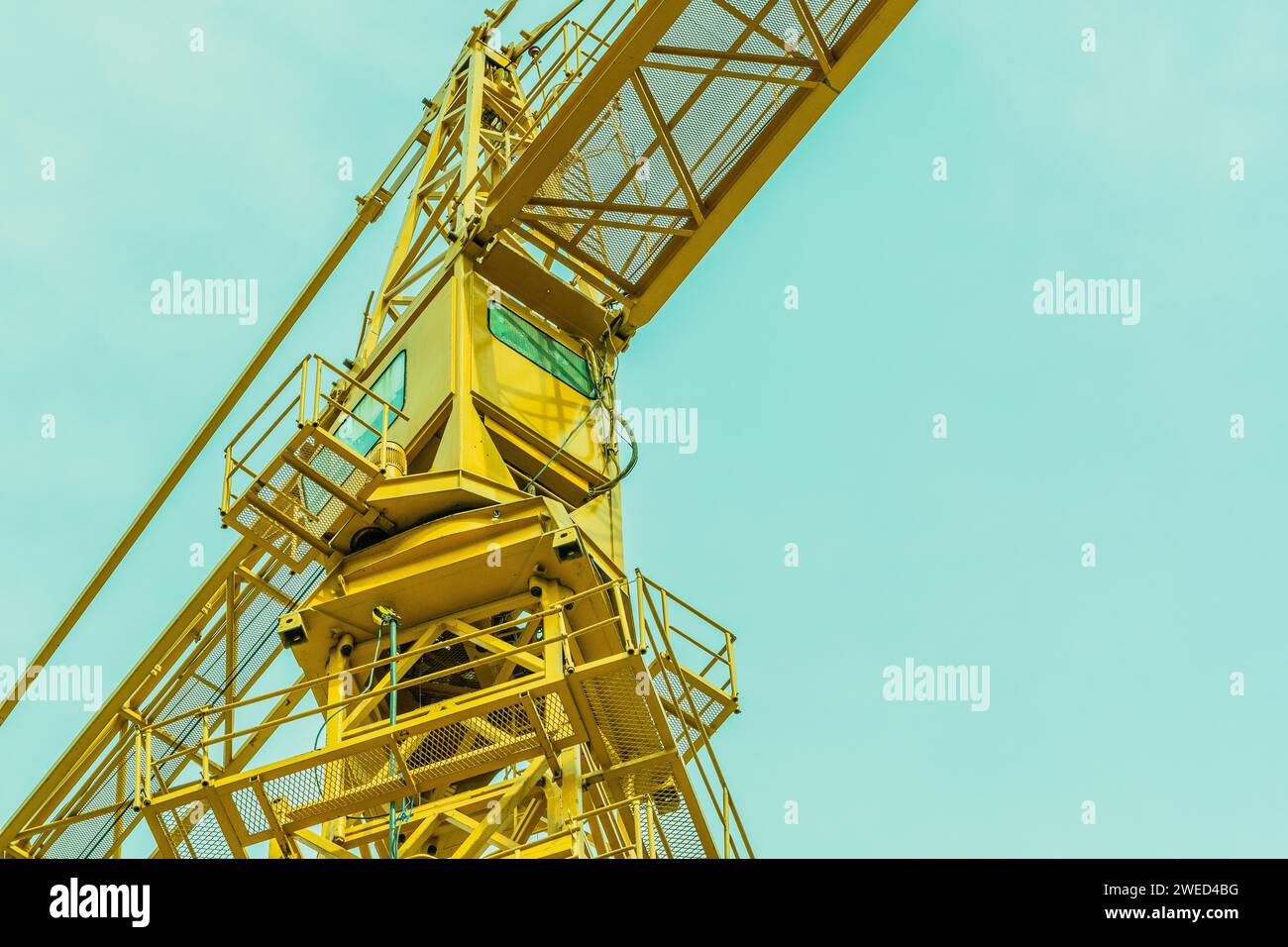 Large yellow construction crane with a background of a clear blue sky ...