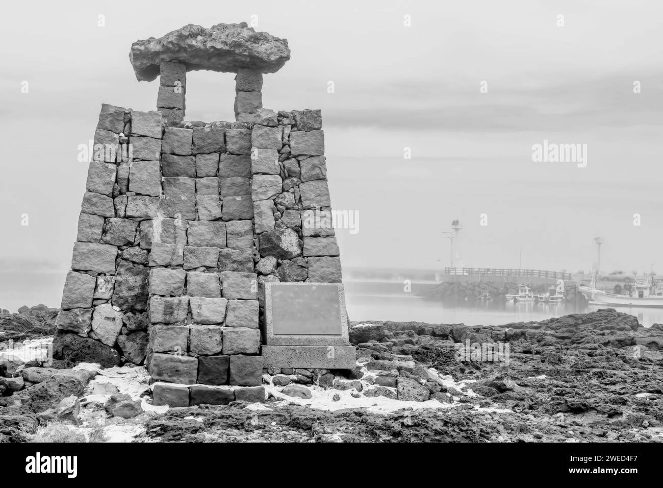 Black and white ancient lighthouse made of square cut stones on coast ...