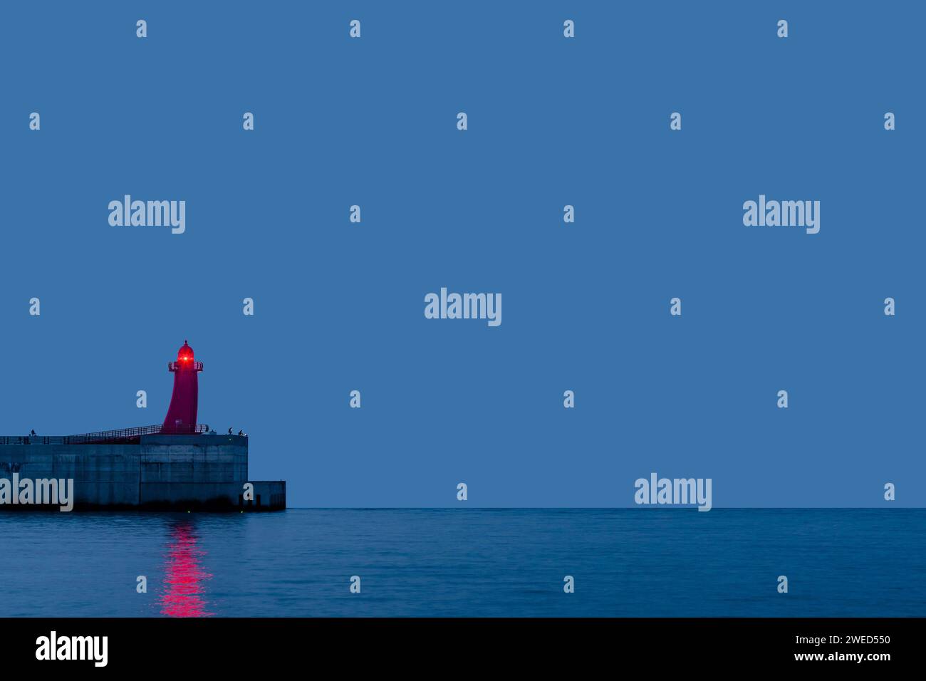 Red lighthouse on end of concrete pier after sunset in Jeju, South ...