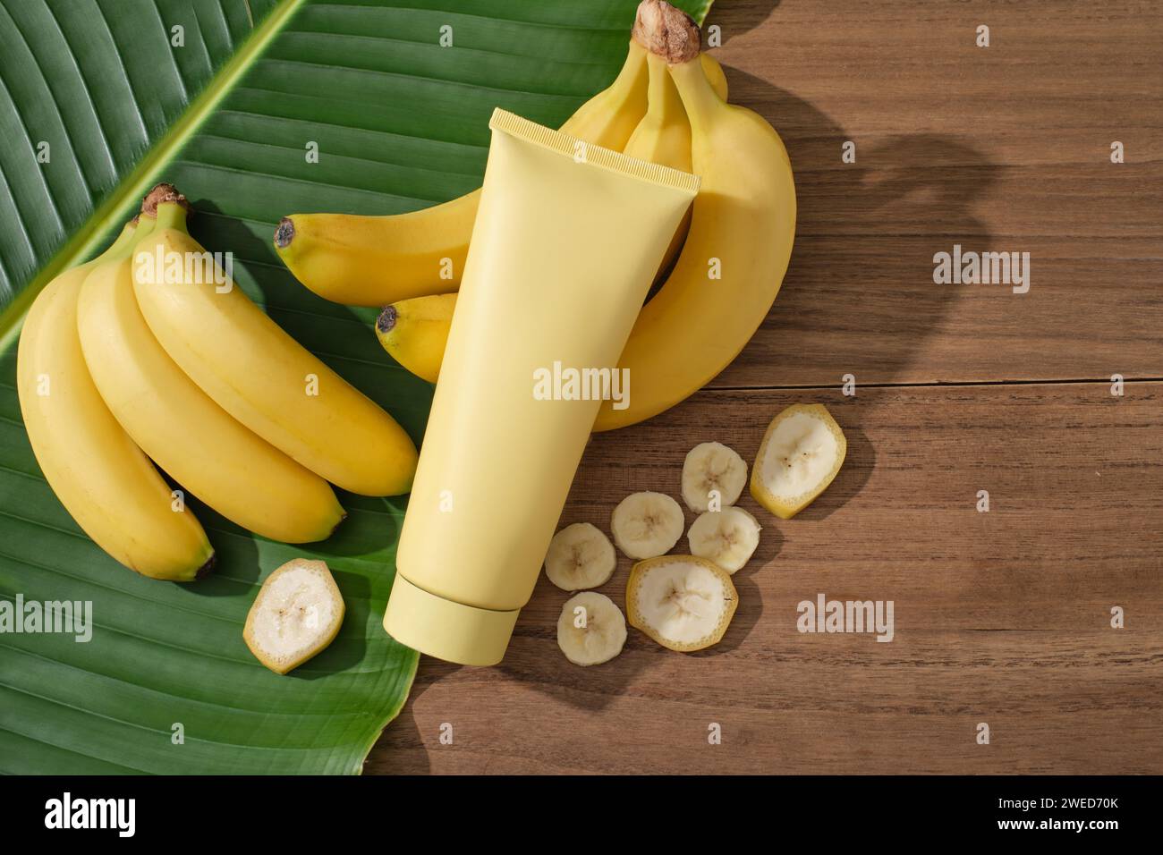 Cosmetic container in yellow color displayed with banana bunches and ...