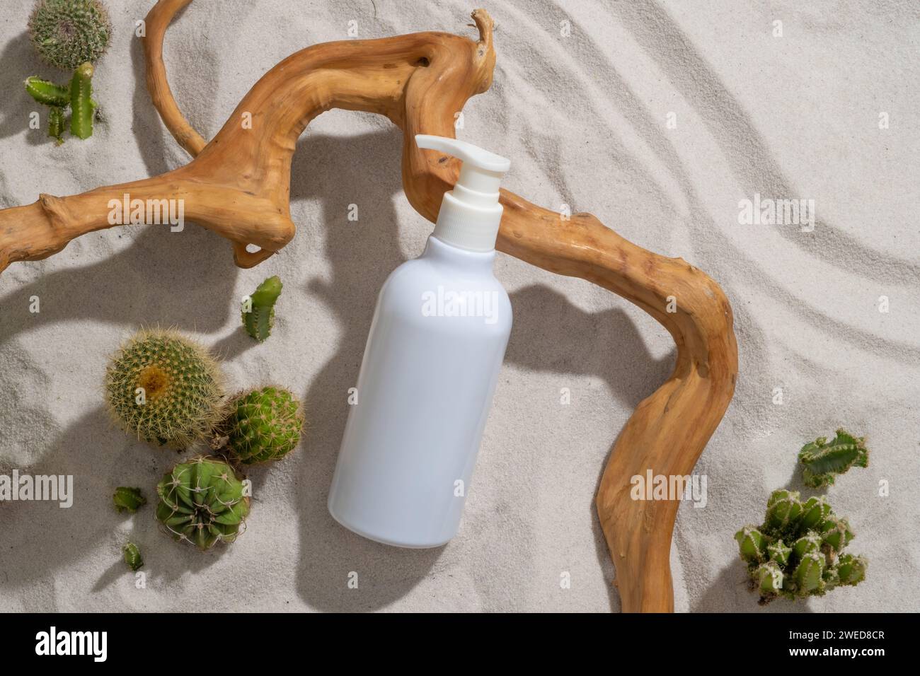 An unlabeled bottle in white color is leaning on a tree branch ...
