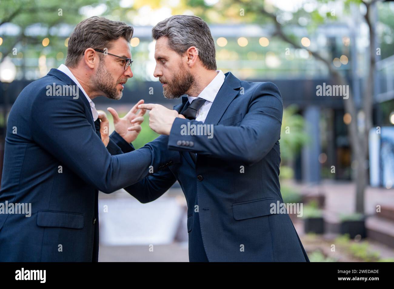 Stressed angry businessmen fighting outdoor. Disagreed men partners ...