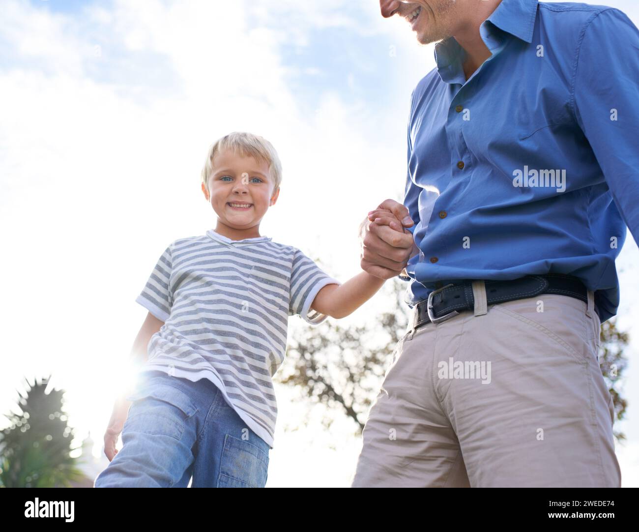 Father, son and happy in nature with holding hands for bonding, trust ...