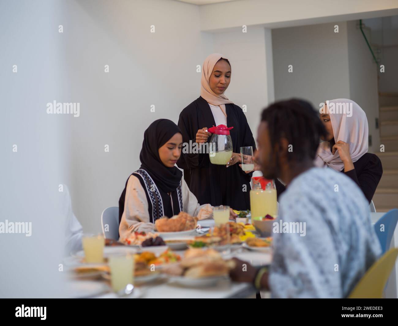 A diverse Islamic family gathers for iftar, joyfully breaking their ...