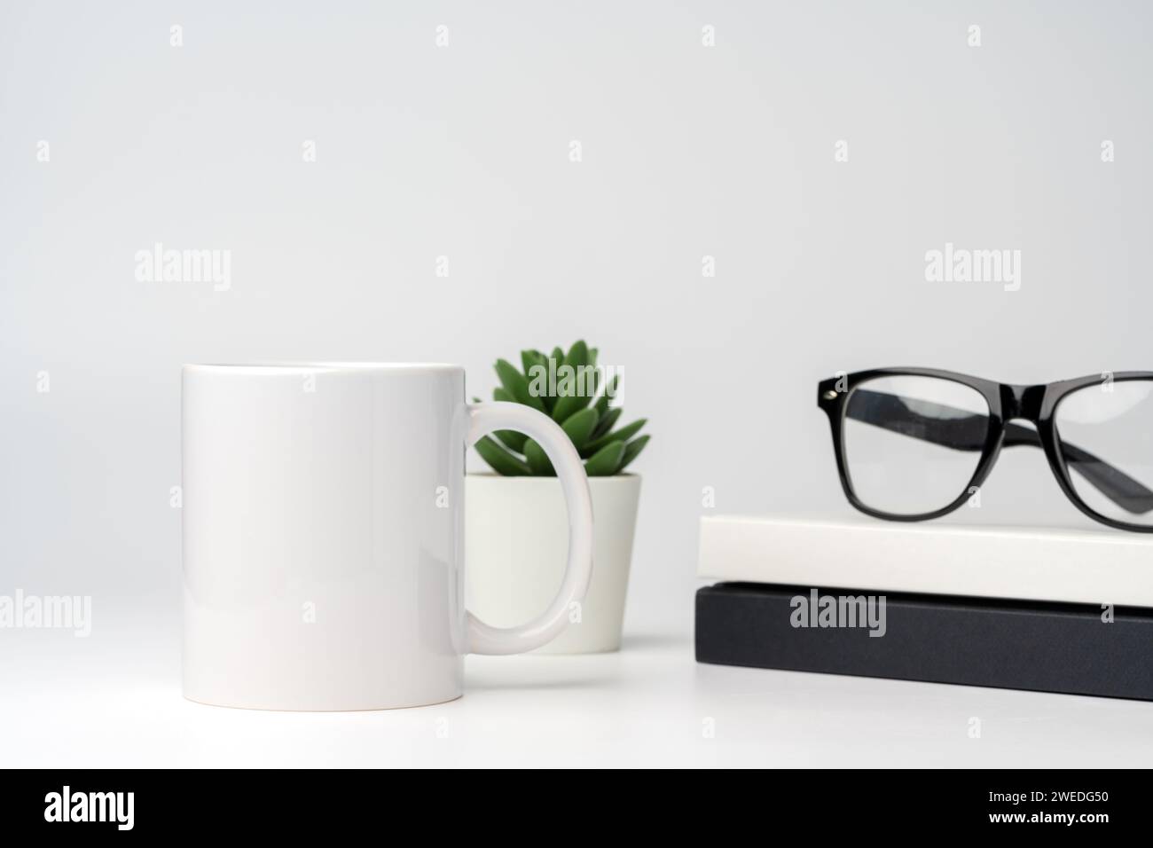 Coffee mug on white office table mock up Stock Photo - Alamy