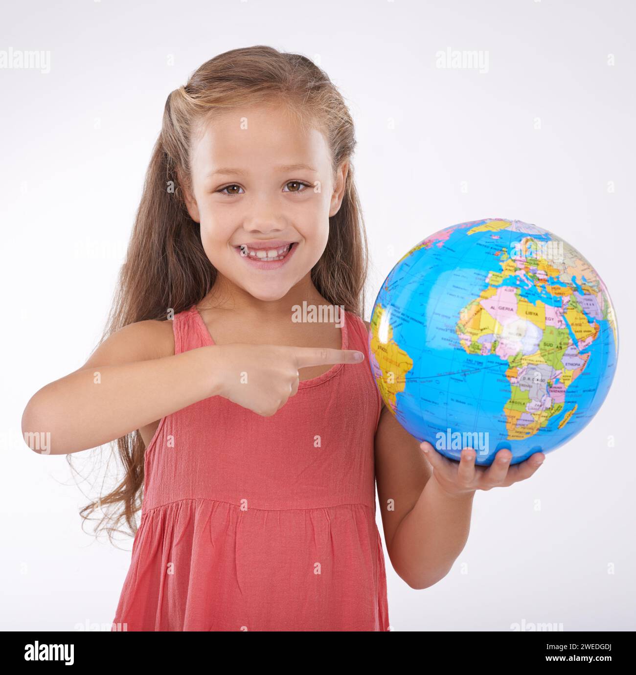 Kid, pointing to globe in studio with world, planets and city for ...