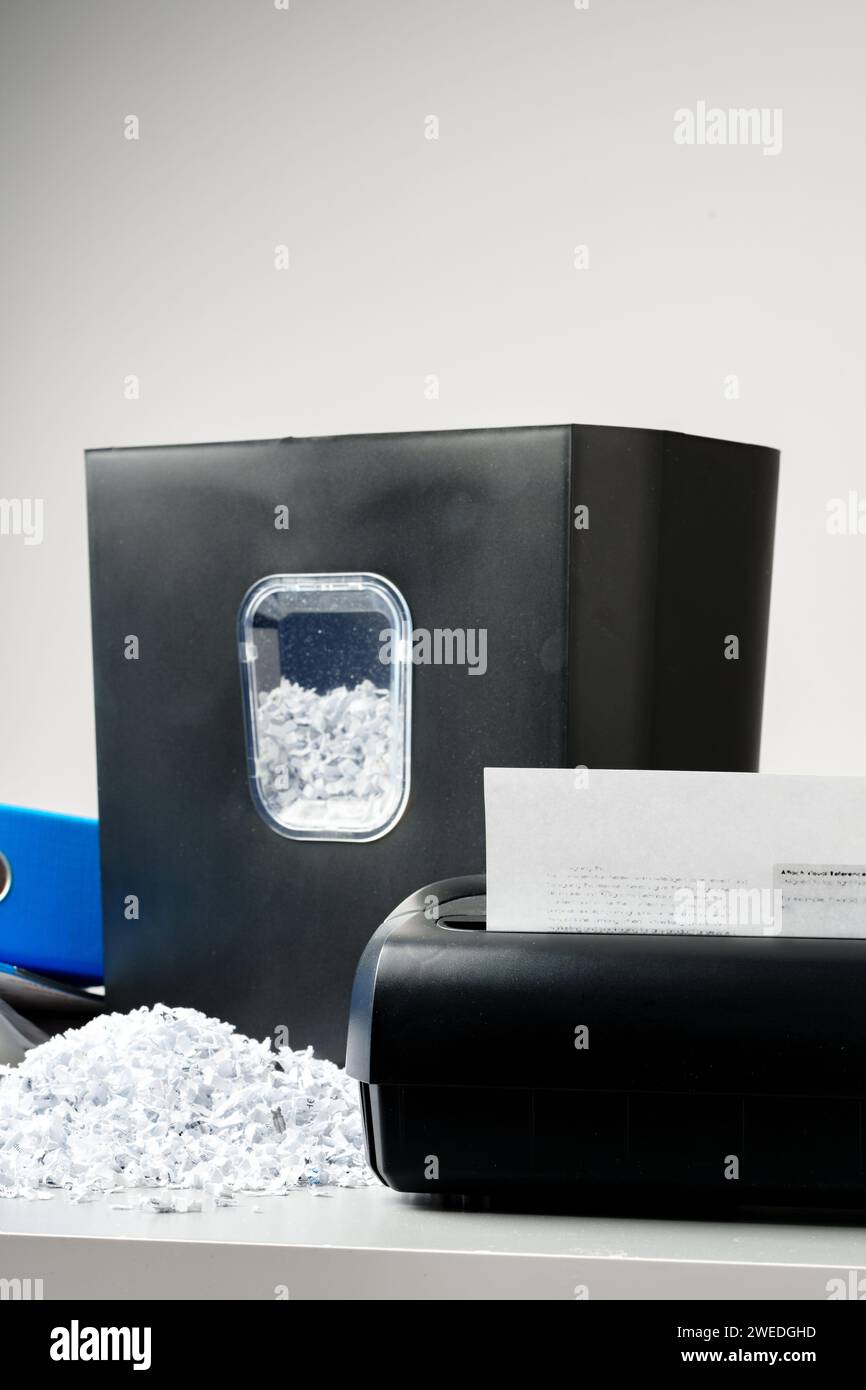 Office paper shredder on table against gray background Stock Photo - Alamy