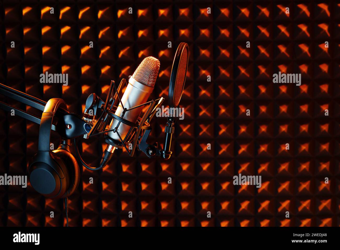Professional studio microphone against acoustic foam panel background ...