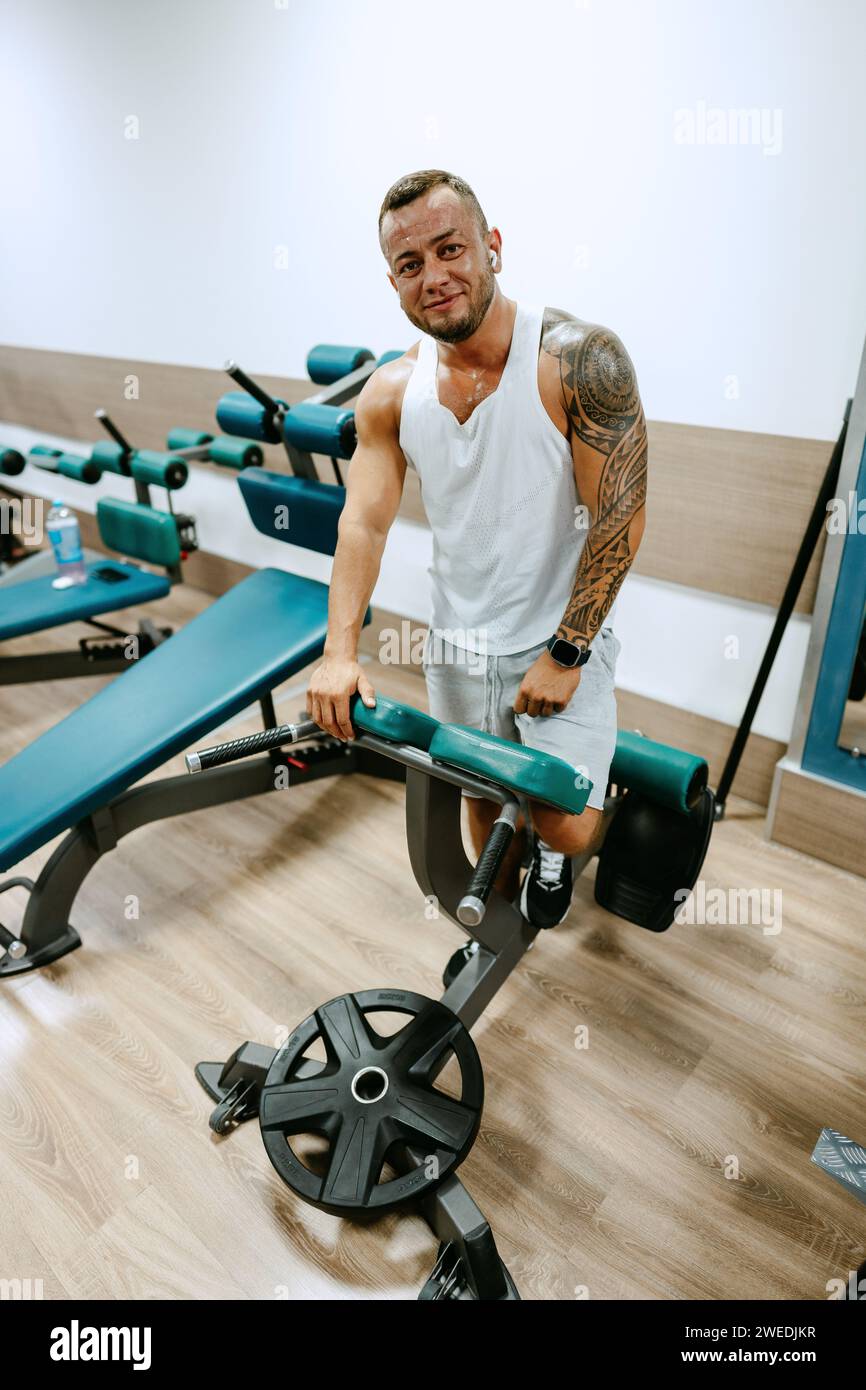 Man bodybuilder in white shirt training in a gym Stock Photo - Alamy