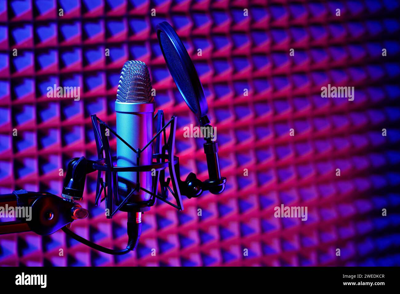 Professional studio microphone against acoustic foam panel background ...