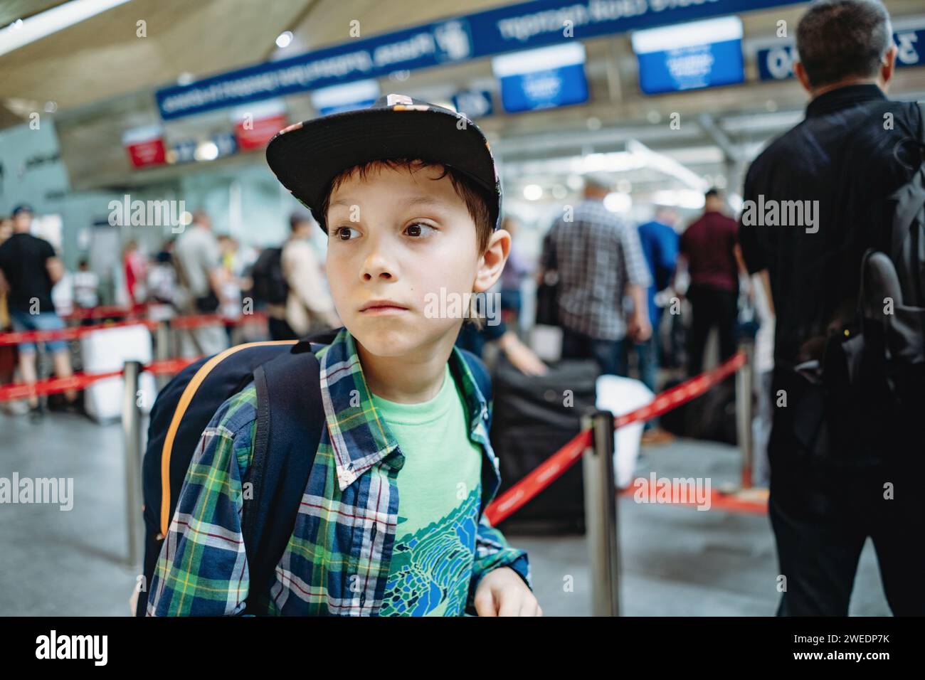 sad caucasian boy in airport with backpack and suitcase. Travelling ...