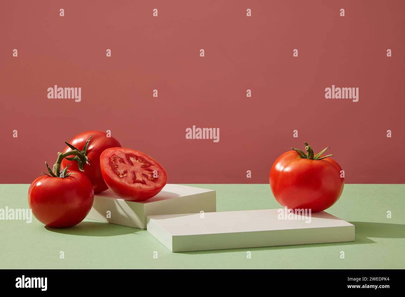Cylinder white podiums decorated with ripe fresh tomatoes on pink ...