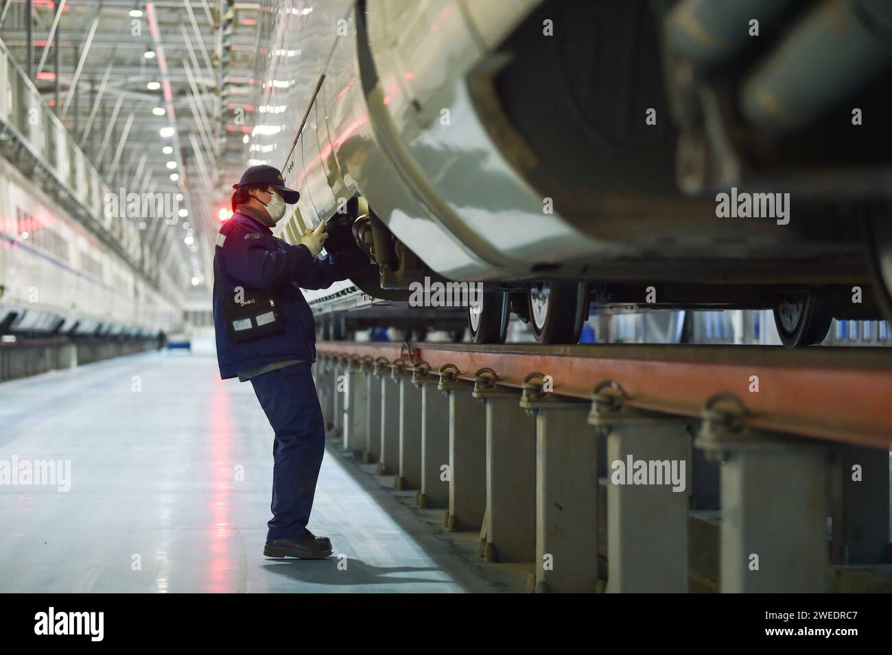 NANJING, CHINA - JANUARY 25, 2024 - A worker inspects a bullet train at ...