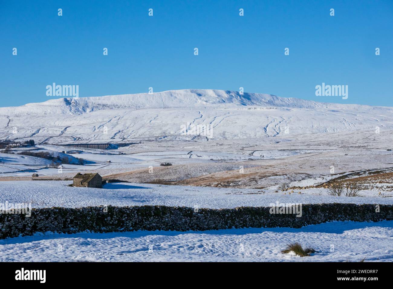 A distant view of the Ribblehead Viaduct under Whernside on a beautiful winter day in the ...