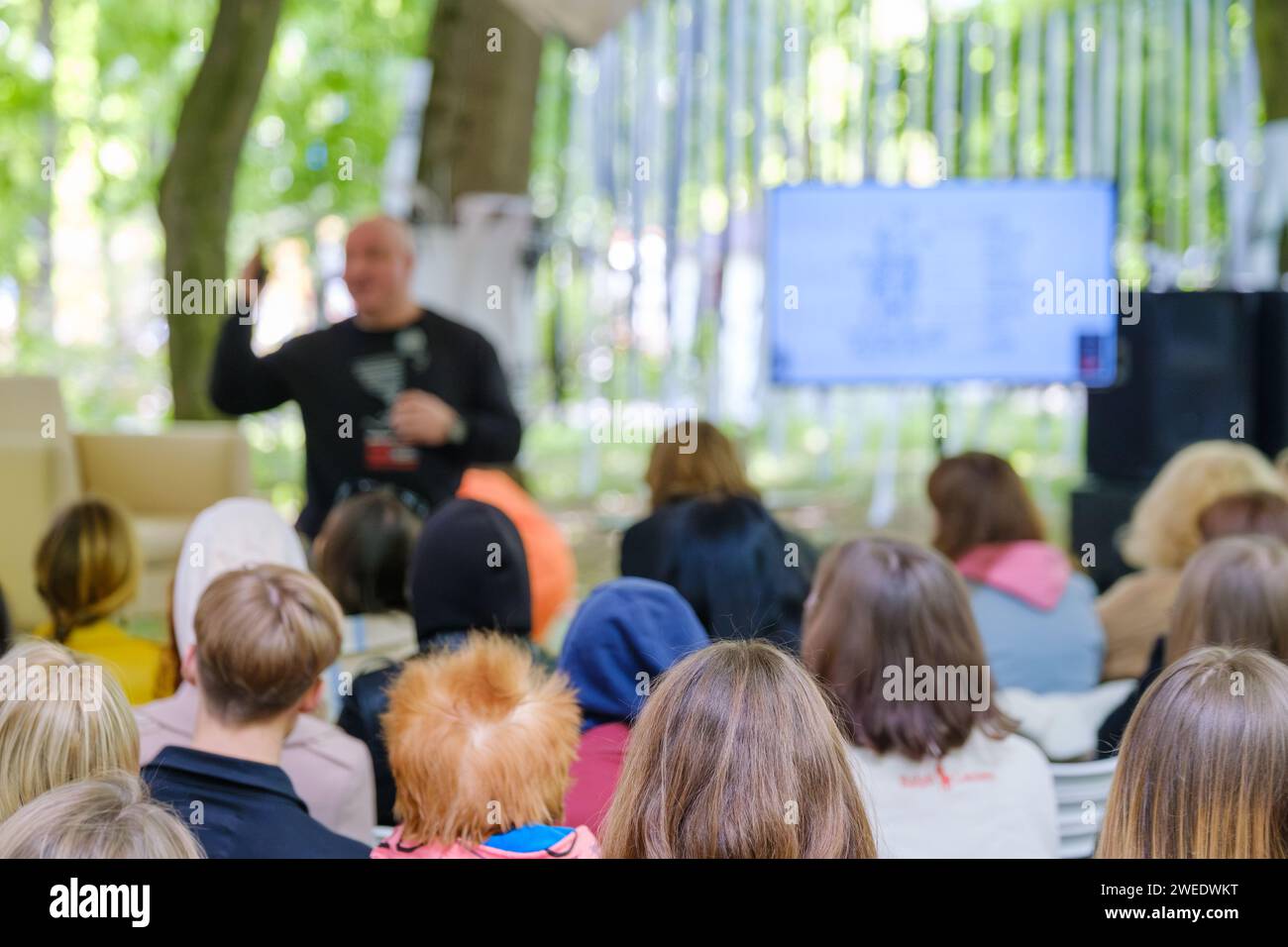 Outdoor workshop scene with attentive audience listening to an ...