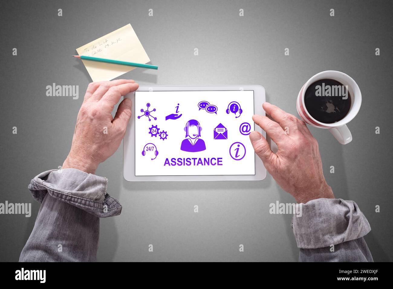 Male hands using a tablet showing assistance concept Stock Photo - Alamy