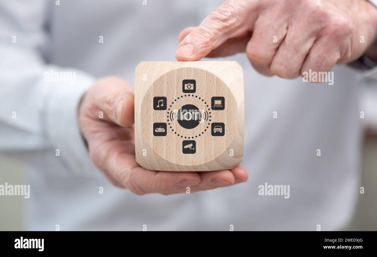 Hand holding a wooden cube with symbol of iot concept Stock Photo - Alamy