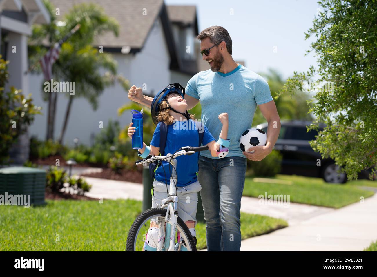 Father teaching son riding bike. Dad helping child son to ride a ...