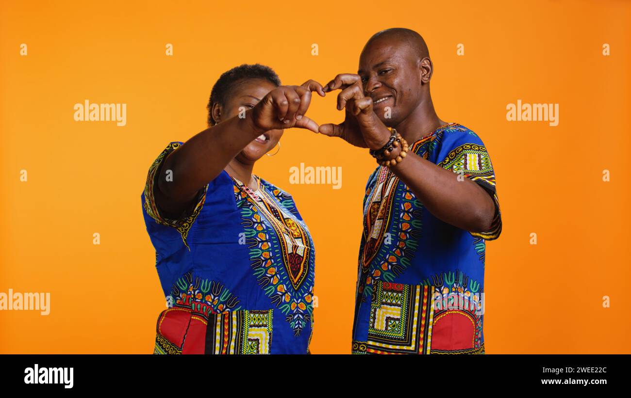 African american couple doing heart shaped sign with their hands ...