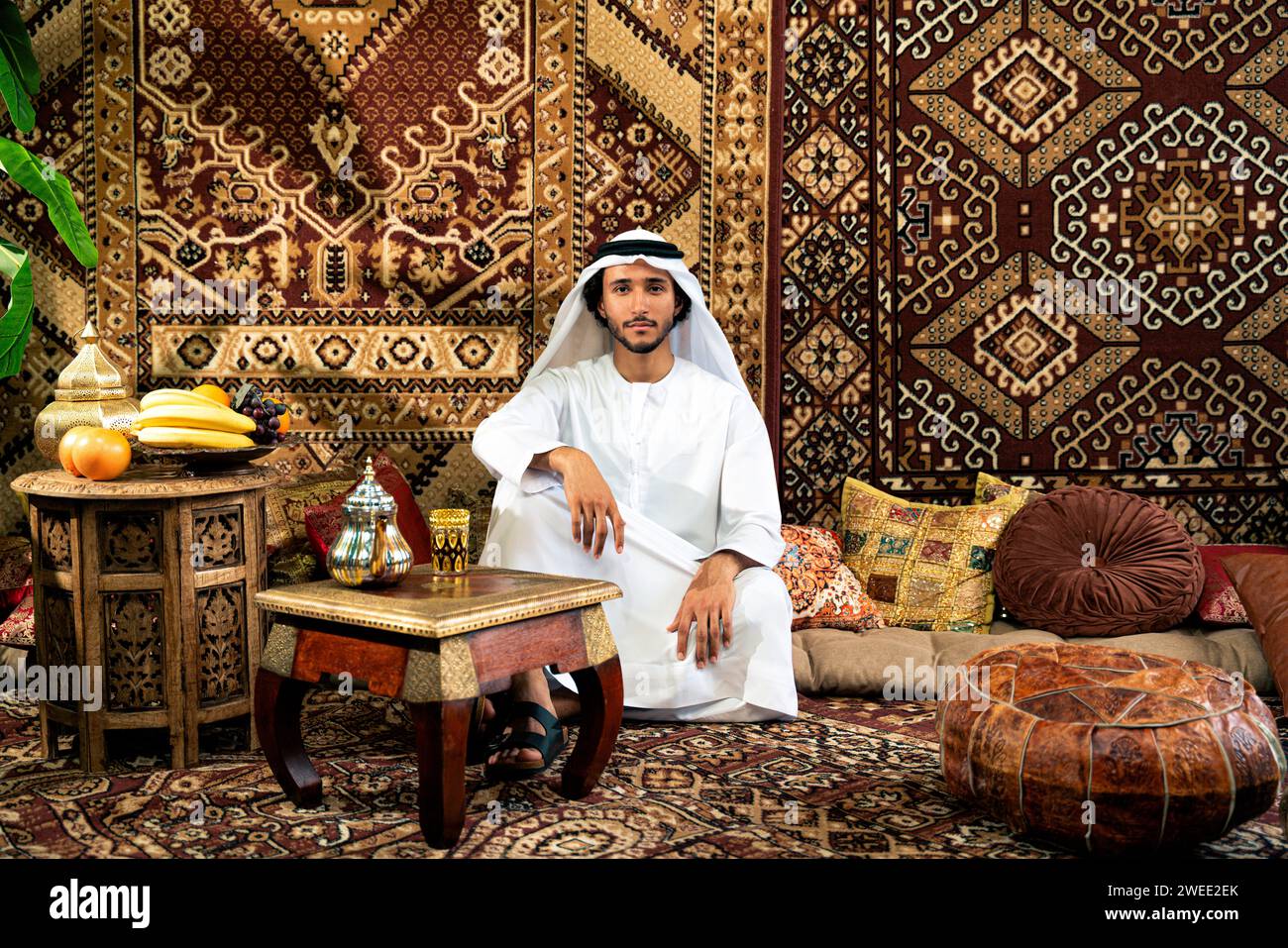 Man from emirati wearing kandura outfit spending time in an arabian ...