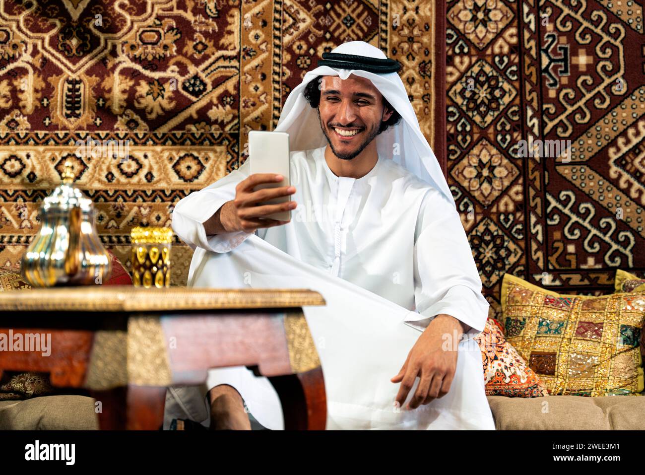 Man from emirati wearing kandura outfit spending time in an arabian ...