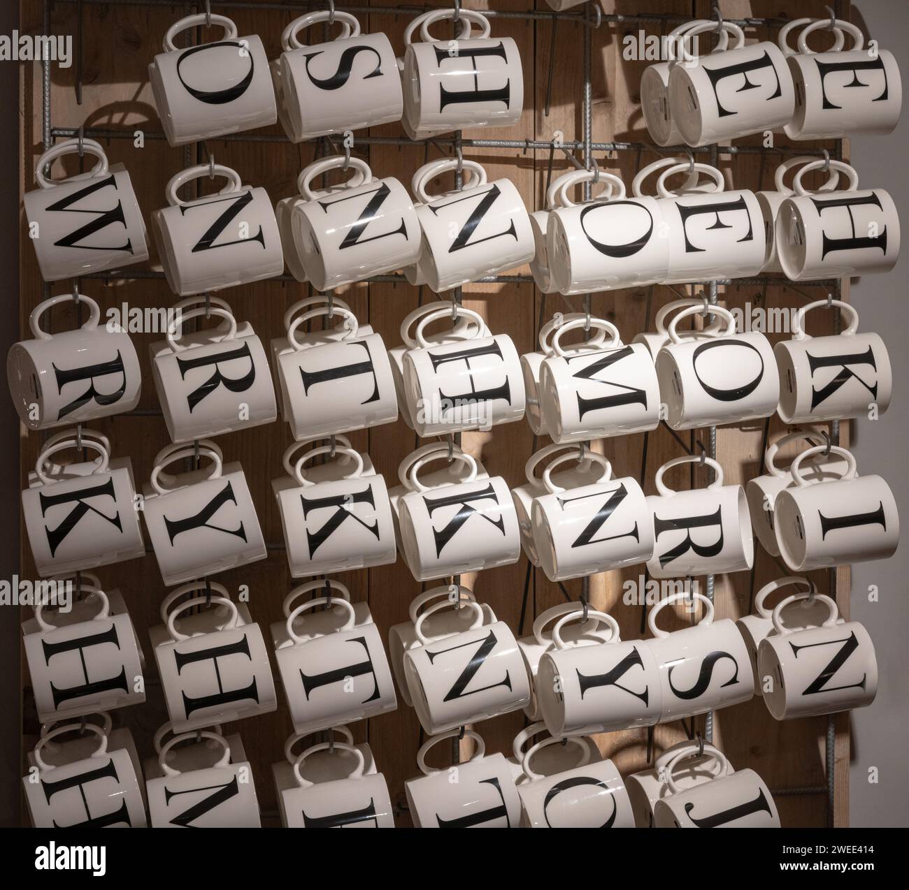 shot of ceramic mugs in a shop with black printd Alphabet letters on it ...