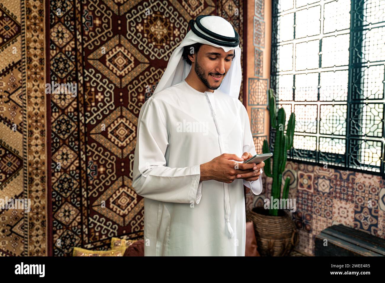 Man from emirati wearing kandura outfit spending time in an arabian ...